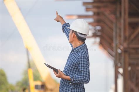 Engineer With Tablet At The Infrastructure Construction Site Man In Hardhat Checking Project At
