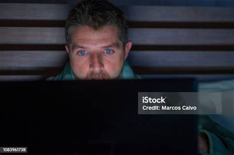 매력적이 고 편안한 인터넷 중독자 젊은이 네트워킹 소셜 미디어 중독 또는 중독 사업 개념에 노트북 컴퓨터와 함께 침대에 밤에 집중 포르노에 대한 스톡 사진 및 기타 이미지