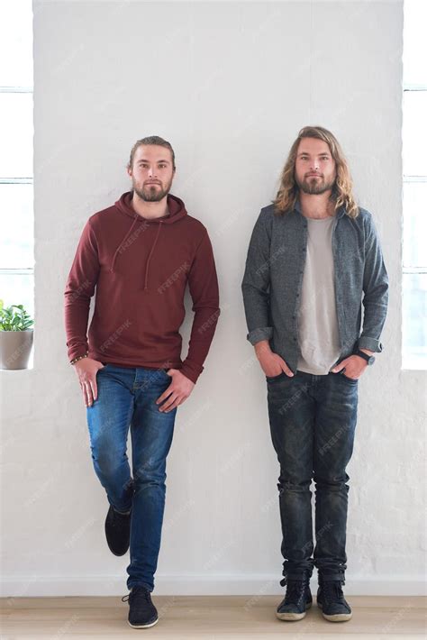 Premium Photo Portrait Of Twin Brothers Standing By A Wall Together