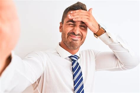 젊은 잘생긴 사업가는 머리에 손으로 스트레스 고립 된 배경을 통해 스마트 폰을 사용하여 셀카를 복용 수치와 깜짝 얼굴 분노와 좌절에 충격 실수에 대한 두려움과 화가 셀카에