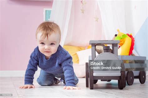 파란 스웨터를 입는 소년 금발 나무 바닥에 크롤링 나무 장난감을가지고 노는 1 년 된 아기 12 23 개월에 대한 스톡 사진 및 기타 이미지 Istock