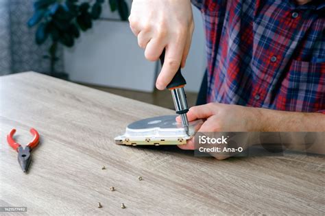 Male Engineer Repairman Disassembles Computer Hard Drive With A Screwdriver Concept Of Repairing
