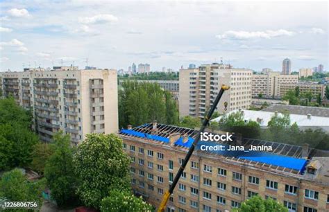 노동자들은 오래된 붉은 벽돌 건물의 지붕을 수리하고 교체합니다 스프링 건설 공사 적절한 형태로 도시 건물의 수리 및 유지 보수 개선에 대한 스톡 사진 및 기타 이미지