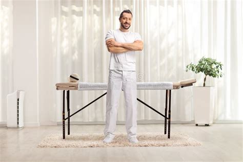 Massage Therapist Standing In Front Of A Massage Table Stock Image