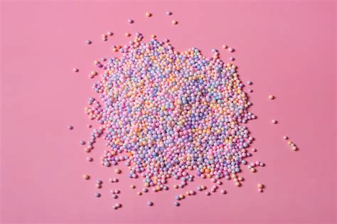 분홍색에 파스텔 색상 공의 더미 스티로폼 또는 폴리스티렌 폼 배경 베이킹과 과자를 장식하는 데 사용되는 다채로운 설탕 공의 혼합 무지개 색 설탕 칩 드래그 스핀 과자 구에