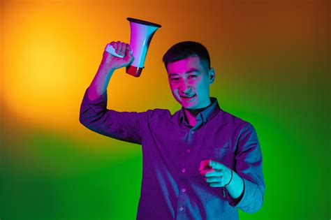 그라데이션 그린 옐로우 네온 라이트 컬러 필터에 스튜디오 배경에 고립 된 아시아 젊은이의 초상화 인간의 감정 얼굴 표정의 개념