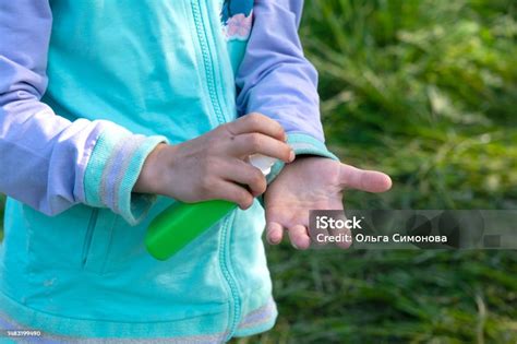 소녀는 그녀의 손과 발을 물린 자연에서 피부에 모기 스프레이를 스프레이합니다 곤충 물림으로부터 보호 어린이를위한 구충제 안전