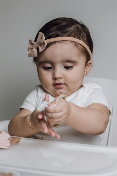 귀여운 노는 시간 높은 의자 달콤한 리본 머리띠 먹이는 의자 사랑스러운 소녀 순수 스튜디오 촬영 아기 아기 돌보기 아기 라이프스타일 아기 용 의복