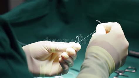 Surgeon Skillfully Threading A Needle While Preparing For A Surgical