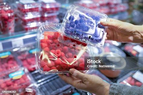 한 여성의 손이 슈퍼마켓에서 신선한 딸기와 라스베리를 따냅니다 신선하고 유기적이며 건강한 제품의 다양한 선택 라즈베리에 대한 스톡 사진 및 기타 이미지 Istock