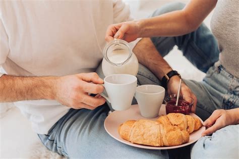 Mano Sirviendo Leche Con Plato De Croisants Foto Gratis