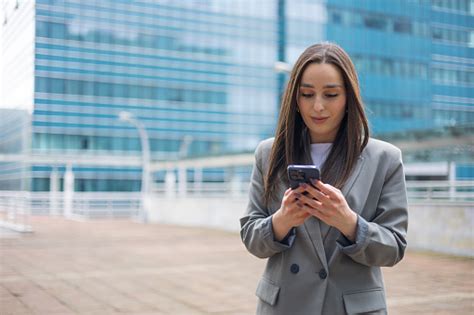 도시의 고층 빌딩 근처에서 스마트 폰을 확인하는 전문 여성 20 24세에 대한 스톡 사진 및 기타 이미지 20 24세 20 29세 Brand Name Smart