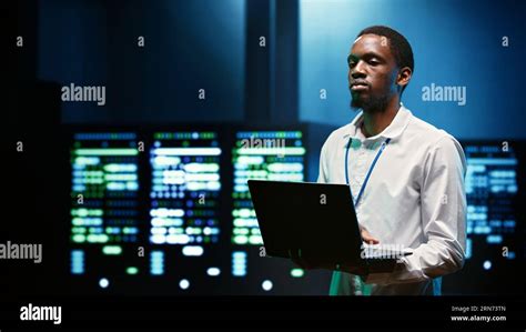 computer scientist in high tech facility using laptop to patch network