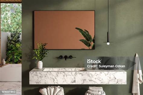 비누 디스펜서 수건 식물 검은색 프레임 거울 펜던트 조명 녹색 벽이 있는 현대적인 욕실 설정 스타일리시한 대리석 세면대에 제품을 진열하는 데 이상적입니다 3d 렌더링