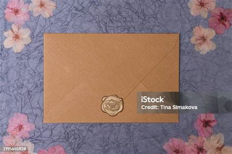 빈 베이지색 공예 봉투 왁스 씰 와 왁스 씰 와 왁스 씰 감사합니다 와 구겨진 회색 파란색 배경에 식물과 꽃의 녹색 나뭇가지와 함께 꽃 봄 템플릿 청첩장 디자인 인사말 카드