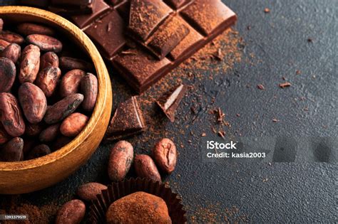 초콜릿 콩 코코아 코코아 파우더 콩 코코아 바 및 검은 색 배경에 다른 우유와 다크 초콜릿 조각의 구성 베이킹 초콜릿 텍스처 복사 공간이 있는 위쪽 보기입니다 모의 초콜릿에