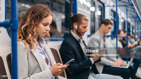 지하철 차에 앉아있는 동안 자신의 장치를 사용하는 젊은 사람들 지하철 철도에 대한 스톡 사진 및 기타 이미지 지하철 철도