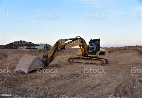 굴삭기는 도로 공사에 건설 현장에서 작업 백호는 기초를 위한 땅을 파고 하수도 라인을 포장합니다 화물의 굴착 적재 리프팅 및 운반을 위한 건설 기계 0명에 대한 스톡 사진