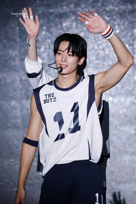 A Male In A White And Blue Shirt Is Holding His Hand Up To The Side