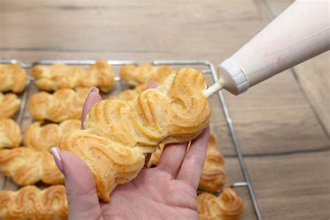 A Woman Fills Eclairs With Custard Mass Using A Pastry Bag Stock Image Image Of Chocolate