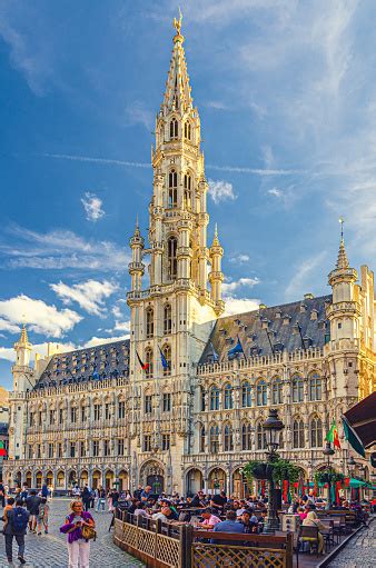 사람들은 브뤼셀 시내 중심가의 시청 브라반틴 고딕 양식의 건물 근처 그랜드 플레이스 그로테 마르크트 빅 마켓 광장의 야외 카페 스트리트 레스토랑에 앉아 있습니다