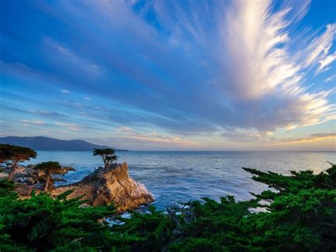 Скалистый морской берег под голубым небом с красивыми белыми облаками обои для рабочего стола