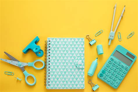 노란색 배경의 파란색 문구 항목과 텍스트 공간이 있습니다 학교 용품창의 창의적이고 다채로운 배경 복사 공간 상단 보기가 있는 플랫레이 마커 펜 종이 클립 가위 교육에 대한