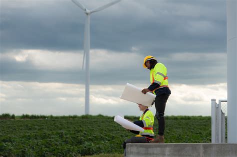 엔지니어와 기술자는 풍력 터빈 분야를 배경으로 대형 풍력 터빈의 타워 베이스에서 함께 작업합니다 바람에서 자연 에너지의 개념 2명에 대한 스톡 사진 및 기타 이미지 Istock
