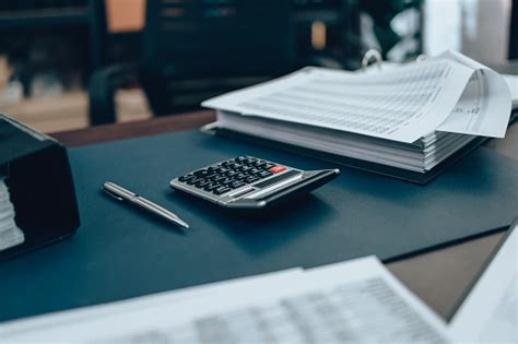 데스크 오피스에서 일하고 계산기를 사용하여 잔액 이익 통화 및 비용을 계산하는 투자자 회계 및 재무 개념 가격에 대한 스톡 사진