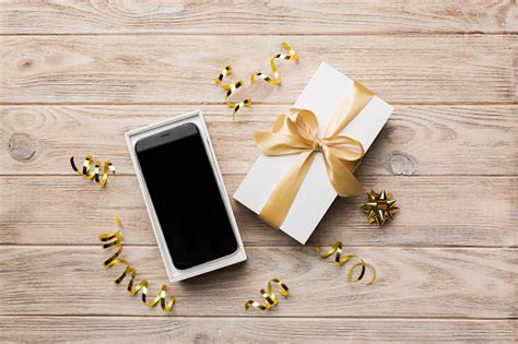 골드 리본과 스마트폰이 있는 기프트 박스를 컬러 배경 상단 보기로 오픈했습니다 빈 오픈 박스 포장 모형 디자인템플릿 브랜딩 모형 Brand Name Smart Phone에