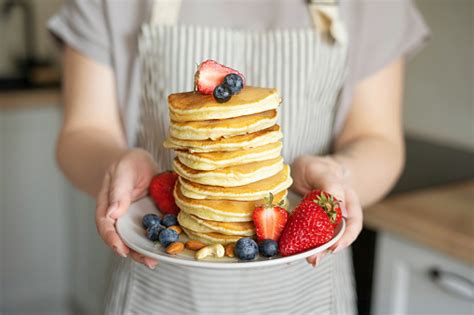 한 여성이 딸기 블루 베리 견과류 및 꿀로 장식 된 팬케이크 접시를 들고 있습니다 더미에 대한 스톡 사진 및 기타 이미지 더미 팬케이크 0명 Istock