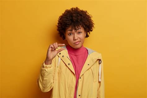 Free Photo Size Matters Unaware Dark Skinned Female Model Shapes Something Very Tiny And Says