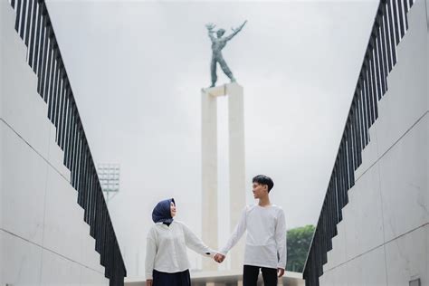 기념물 남자 무슬림 서 있는 손을 잡고 여성 커플 패션 사진 흰옷 히잡에 관한 무료 스톡 사진