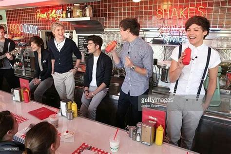 A Group Of Young Men Standing Around A Diner