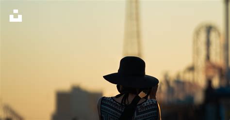 낮 동안 갈색 타워 근처에 서 있는 검은 모자를 쓴 파란색과 흰색 격자 무늬 셔츠를 입은 남자 사진 Unsplash의 무료 뉴욕 이미지