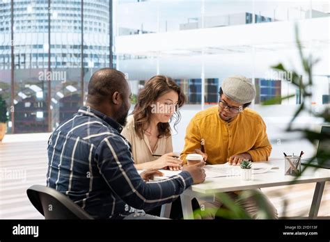 Professional Clients And Their Real Estate Agent Evaluating Blueprints