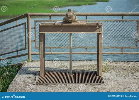 water valve on a dam with water to set the overflow value for the water safety measure on a