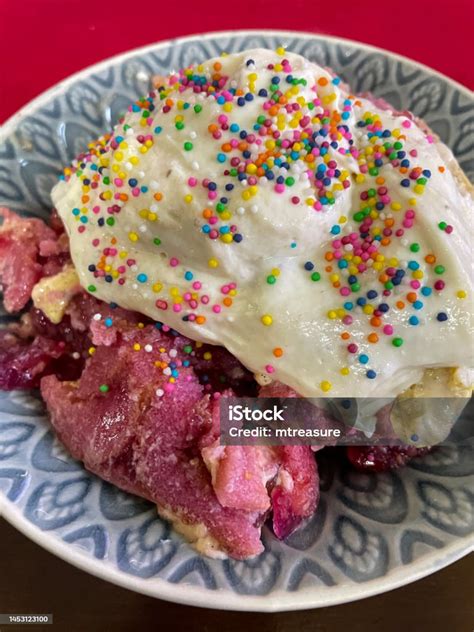 무지개 멀티 컬러 설탕 스프링클 스폰지 케이크 커스터드 및 딸기 젤리 레이어 분홍색 배경 높은 전망으로 휘핑 크림 토핑을 얹은