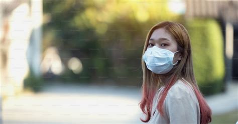 의료 마스크를 착용하고 야외에서 전화를 사용하는 아시아 여성 사진 Unsplash의 통신 이미지