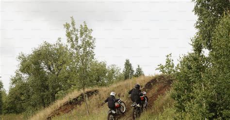 거친 도로에서 언덕을 오르는 동안 속도에 도달하는 헬멧을 쓴 극단적인 오토바이 운전자의 뒷모습 사진 Unsplash의 수송 이미지