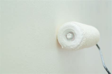 롤러 브러시 페인팅 표면 벽 페인팅 아파트에 작업자 페인팅 화이트 컬러 페인트로 개조 빈 복사 공간을 흰색으로 두어 옆에 설명 텍스트를 씁니다 가정의 방에 대한 스톡 사진