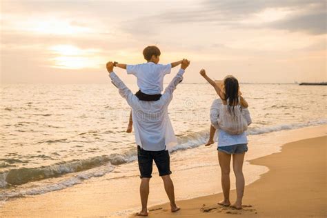 Padre Madre E Figli Si Divertono Insieme Con Una Spalla Sulla Spiaggia