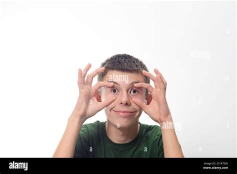 A Young Boy Makes A Funny Face Playfully Covering His Eyes With His