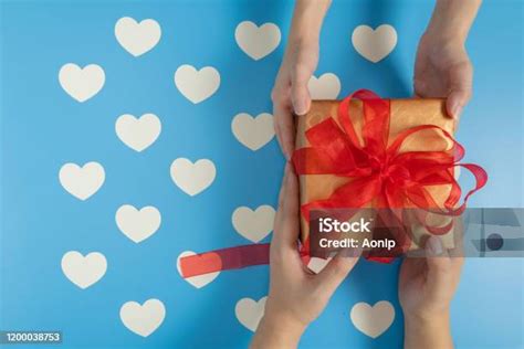 누군가가 십자가 체스 패턴에 설정 흰색 심장과 파란색 배경에 빨간색 리본으로 묶여 갈색 선물 상자를 보내는 개념에 대한 스톡 사진 및 기타 이미지 Istock
