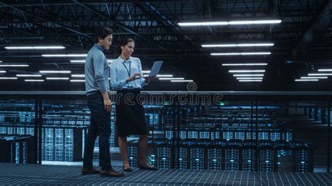 Portrait Of A Data Center Engineer Using Laptop Computer Server Room Specialist Facility With