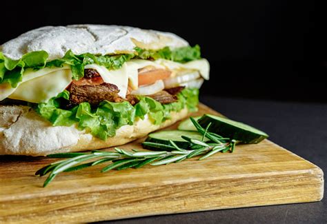 검은 배경 로즈마리 오이 나무 보드 길거리 음식에 큰 샌드위치 패스트푸드 쇠고기와 함께 수 제 햄버거 나무 테이블에 치즈 몸매 이미지입니다 0명에 대한 스톡 사진 및 기타