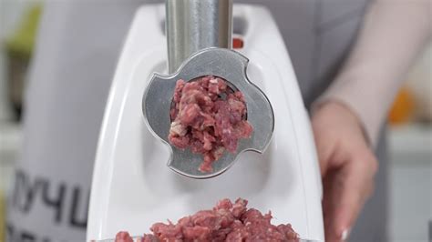 집에서 신선한 쇠고기에서 전기 고기 분쇄기에 다진 고기를 만들기 다진 고기 더미 신선한 다진 고기와 전기 광부 기계 전기 고기 분쇄기로 다진 쇠고기의 준비 가루로 빻은에