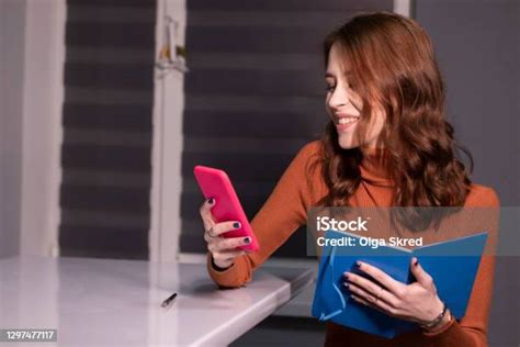 회색 방에 테이블에 앉아 분홍색 케이스에 파란색 노트북과 전화와 갈색 골프에서 매력적인 갈색 갈색 여자 일 교육 연구 분홍에 대한 스톡 사진 및 기타 이미지 Istock