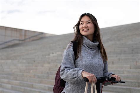 교통에 사용되는 전기 스쿠터를 사용하는 젊은 성인 무료 사진