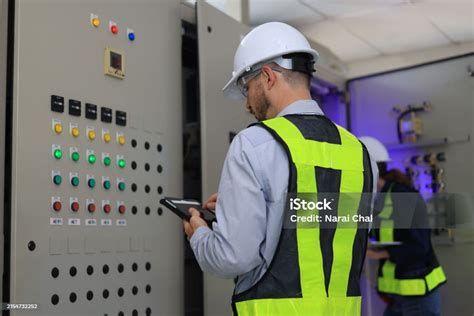 공장의 주 전기 제어실에서 컴퓨터와 디지털 태블릿으로 작업하는 두 명의 백인 백인 전문 전기 기술자 Mdb 주 배전반 2명에 대한 스톡 사진 및 기타 이미지 Istock